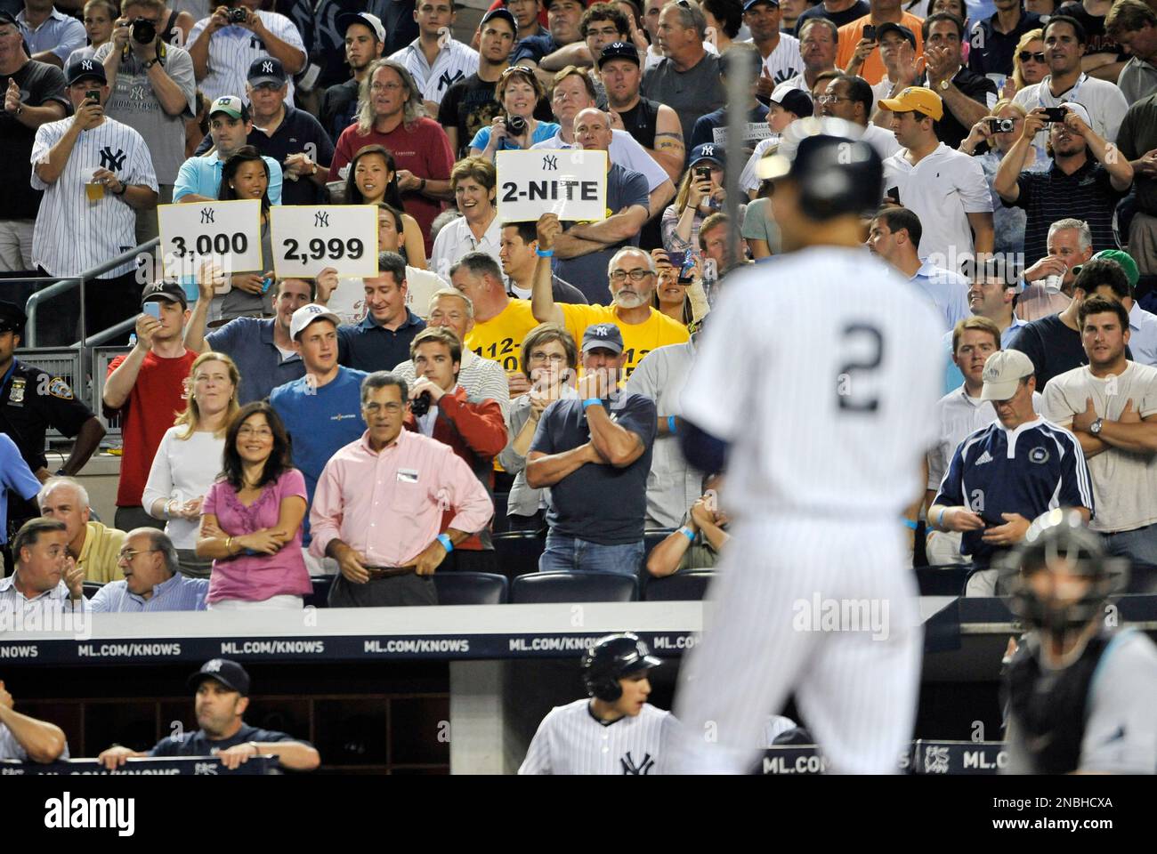 New York Yankees fans hold signs to cheer Derek Jeter as he stands at home plate to bat against ...