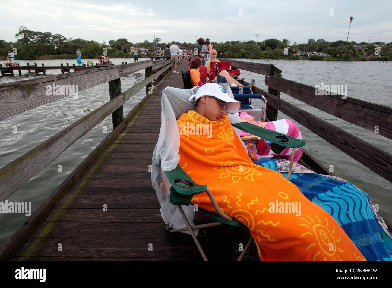 A young boy sleeps while others wait for the launch of space shuttle ...