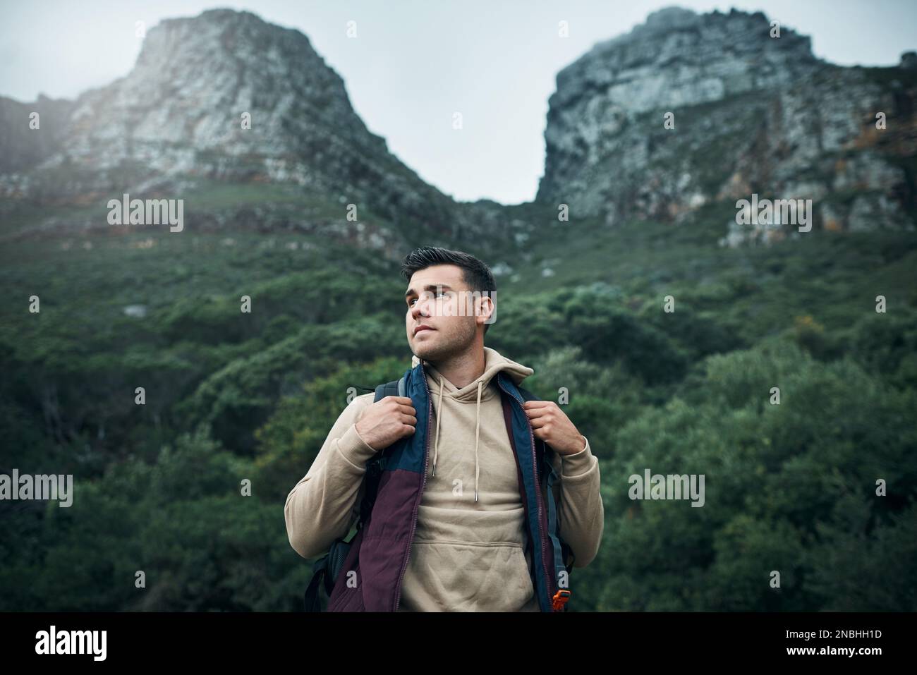 Move the body, still the mind. a young man hiking through the mountains ...