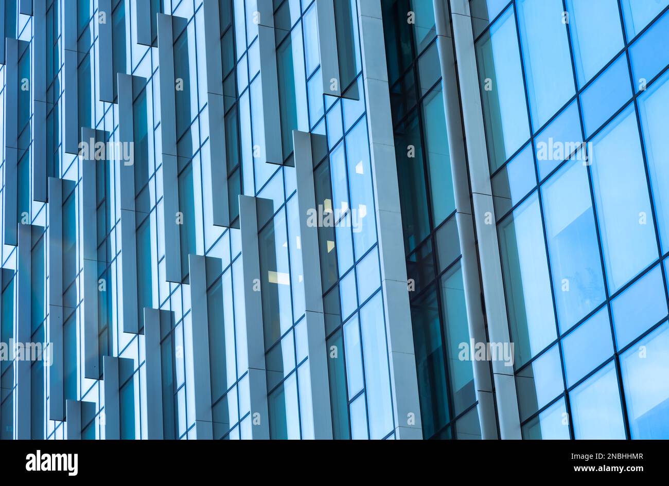 The blue sky is reflected in the windows of a modern office building ...