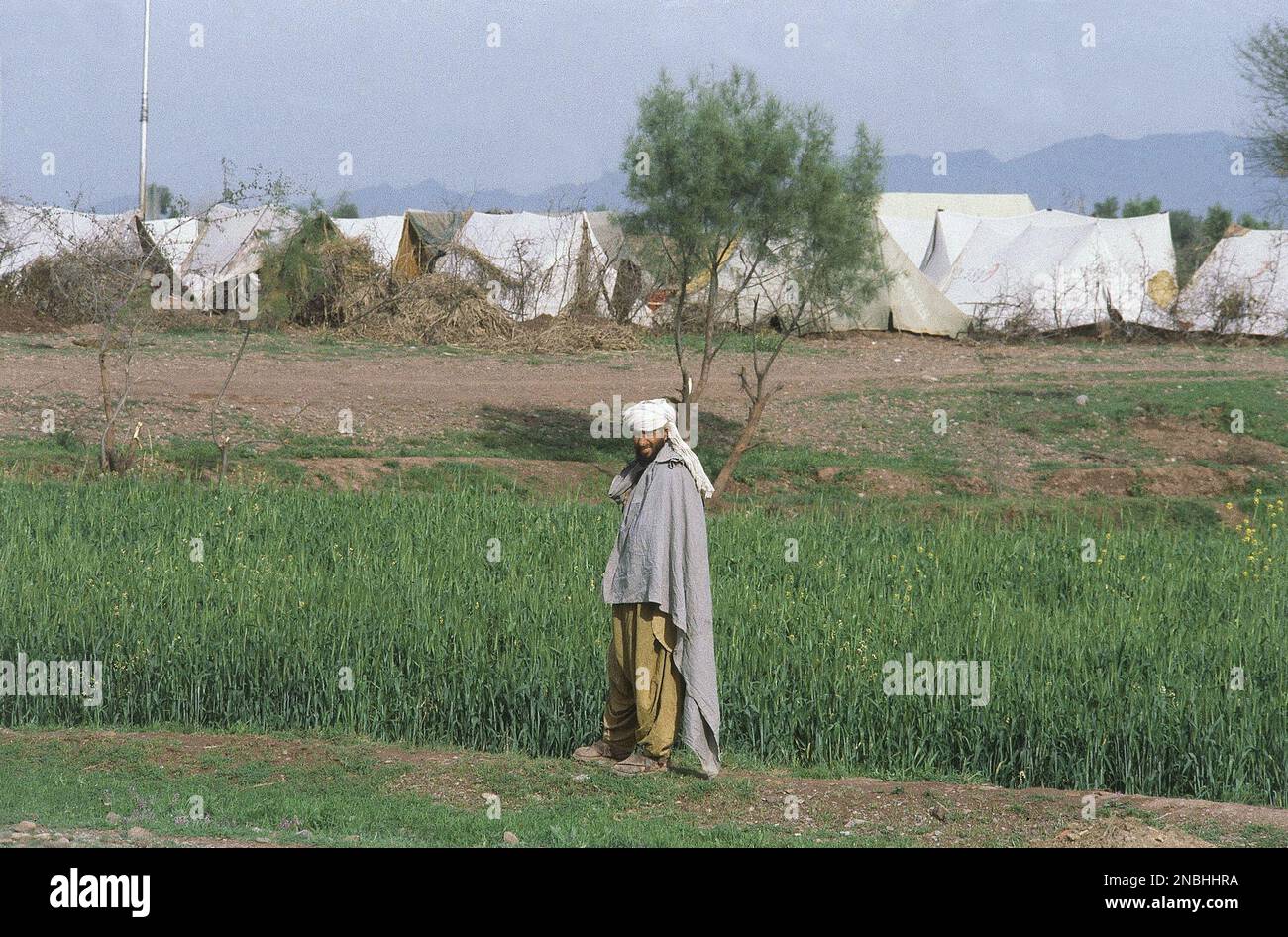 A man walks near Afghan refugee camp on Kohat Road outside of Peshawar ...