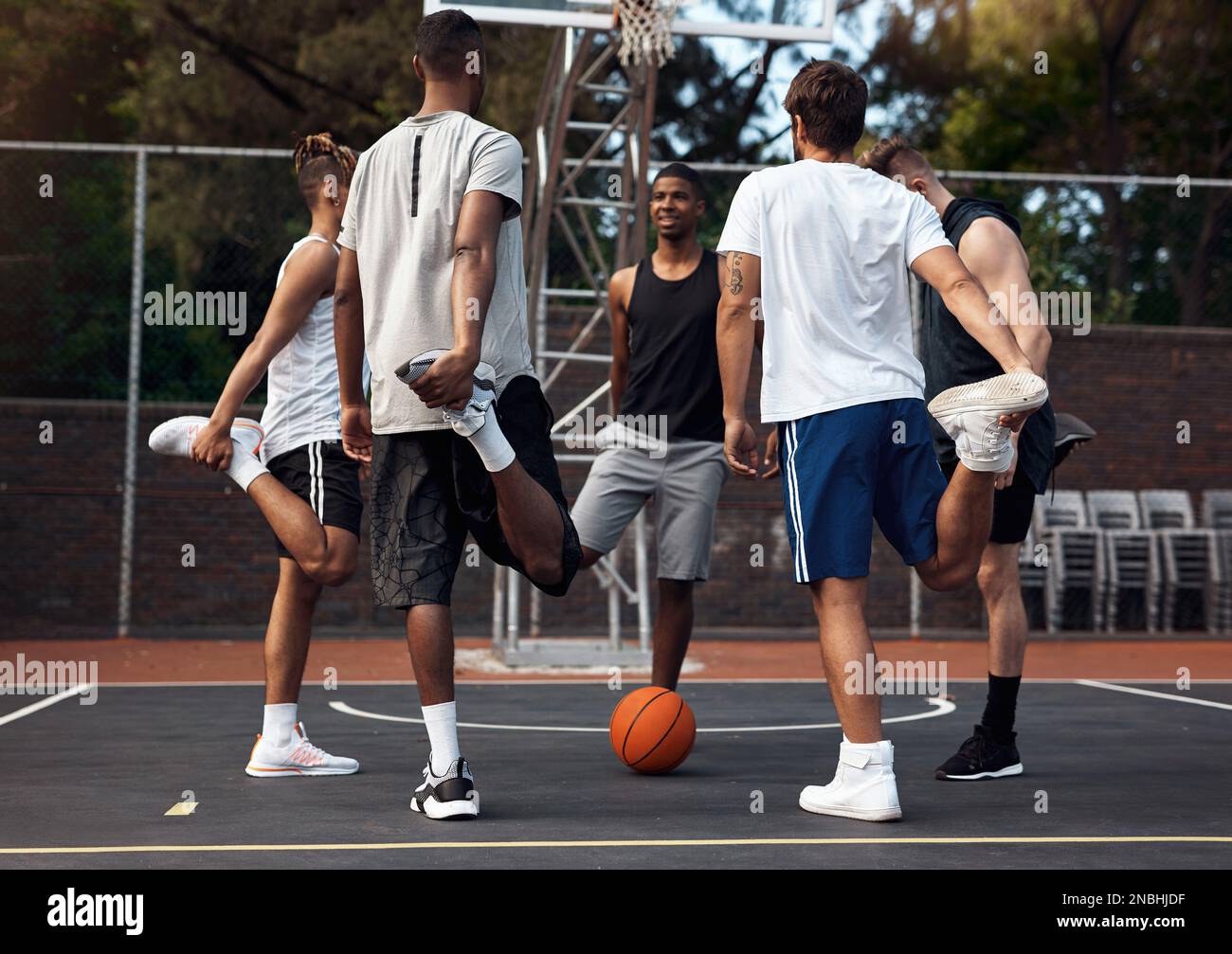 Warming up for a big game. a group of sporty young men stretching their ...