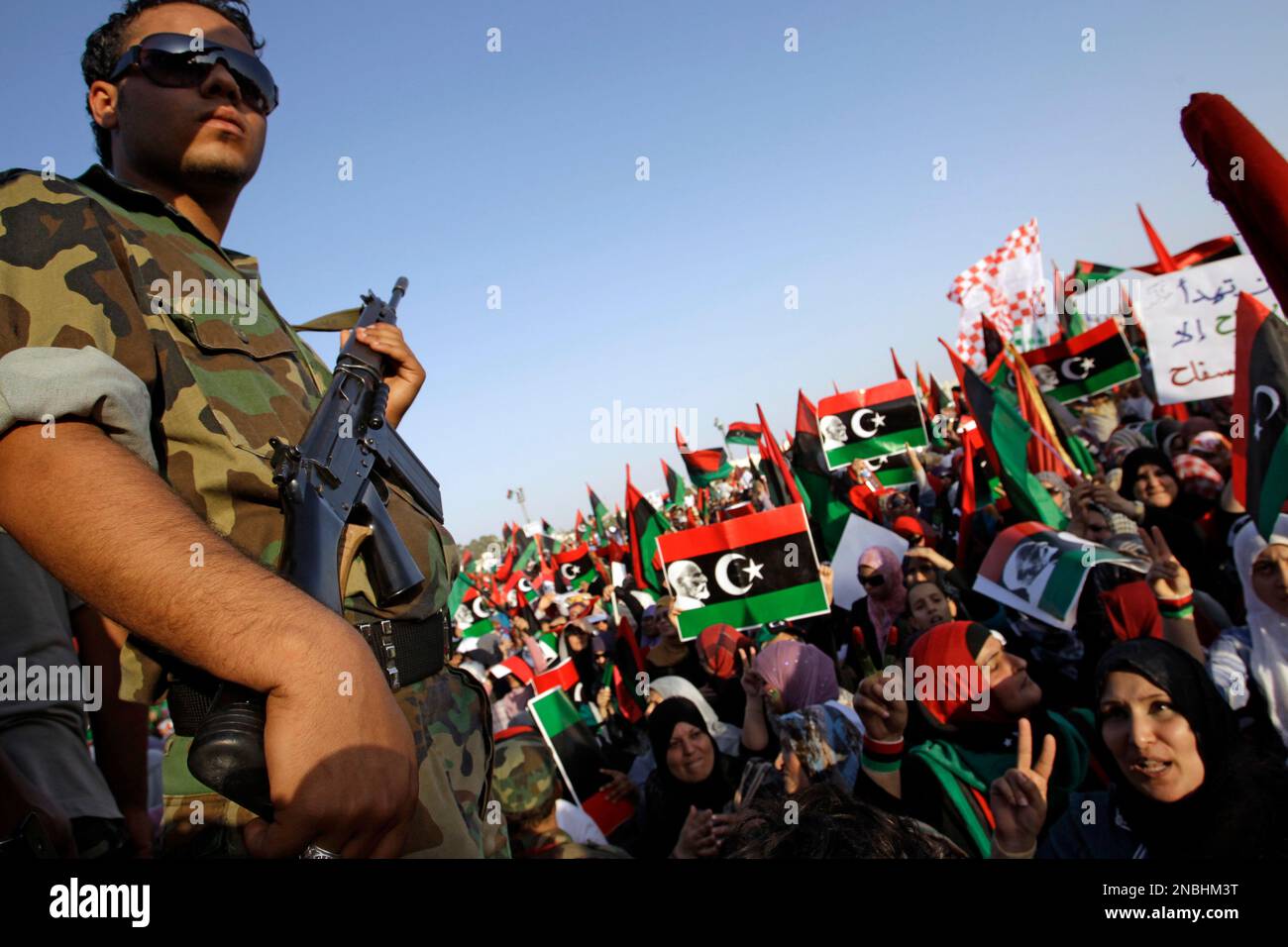 A Libyan man stands on guard during a rally in the rebel-held city ...