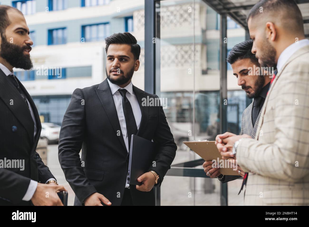 Business people outdoor meeting. Men in jackets discuss working moments ...