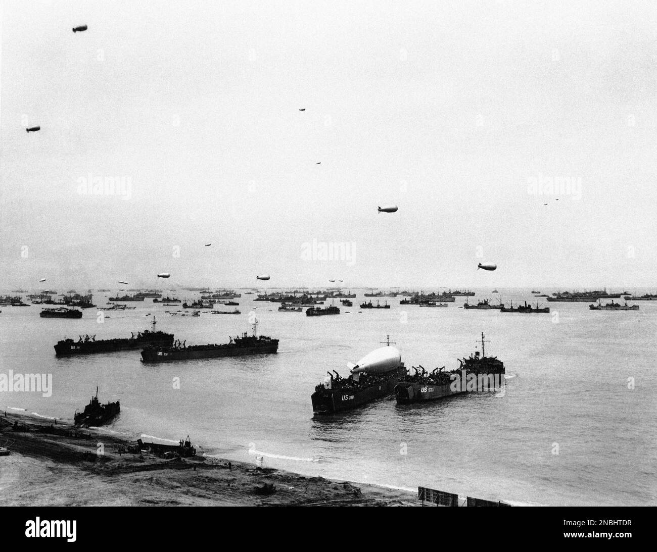 Loaded Coast Guard and Navy-Manned invasion craft crowd the waters off the Normandy Beach on ...
