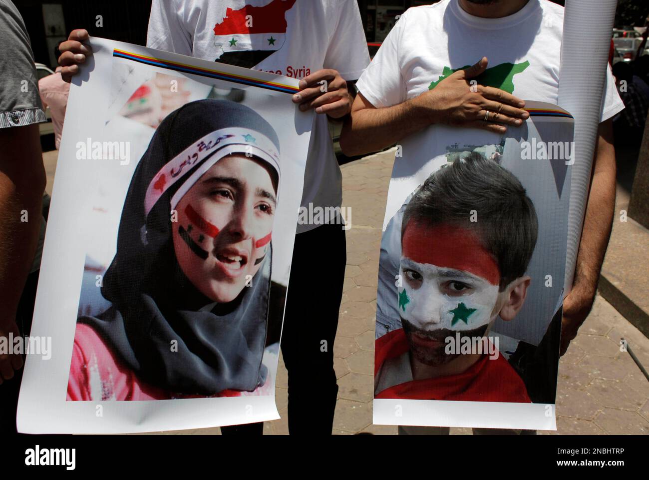 Two protesters carry posters with pictures of unidentified relatives in ...