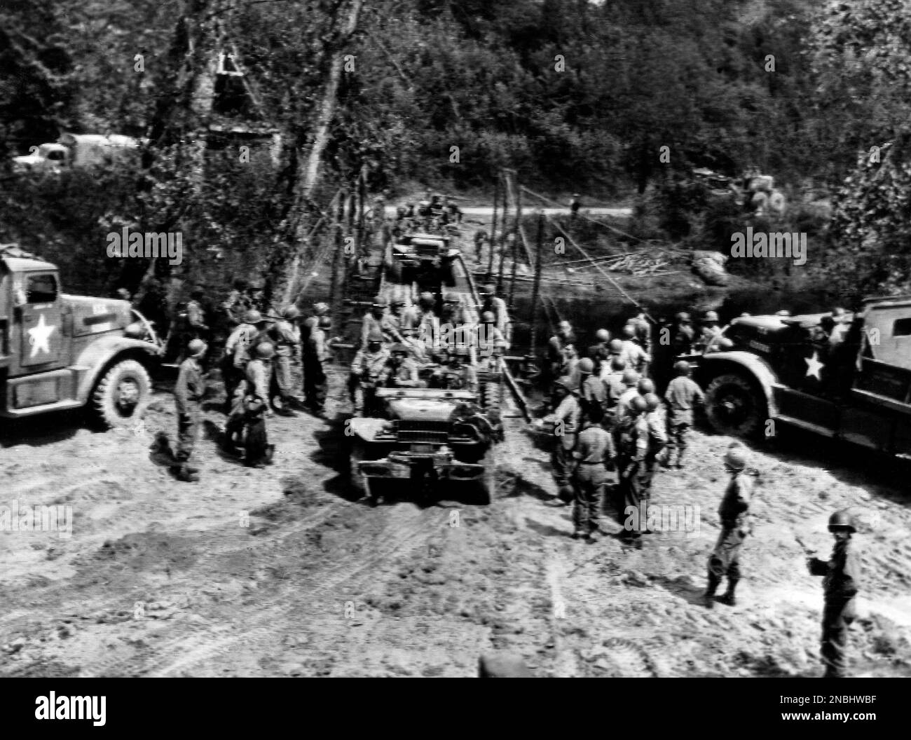 Vehicles use a newly constructed bridge over the Vire river in France ...