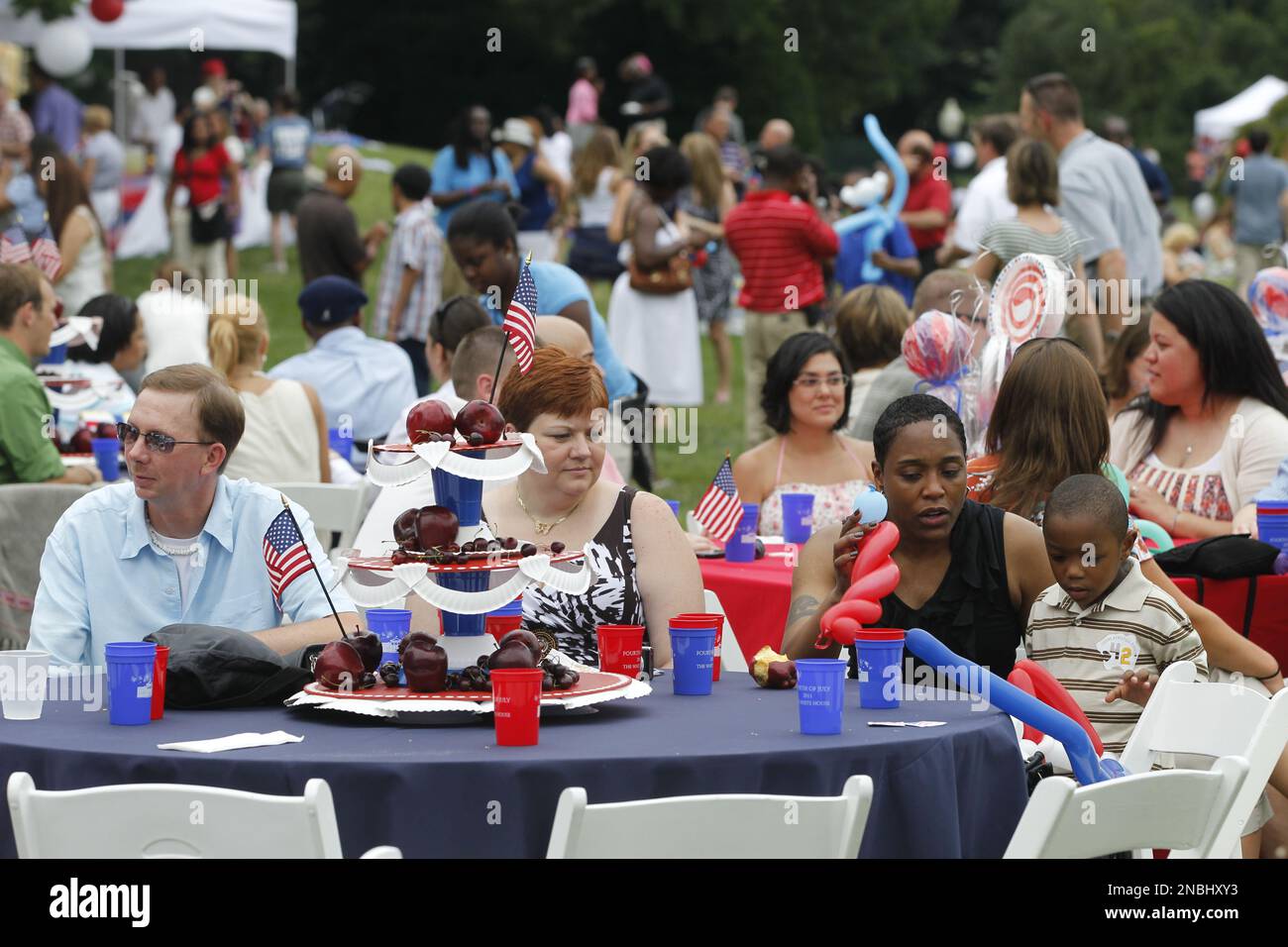 Military families sit at tables on the South Lawn as President Barack ...