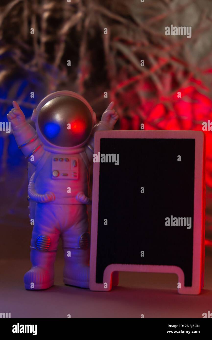 Plastic toy figure astronaut on with red and blue light Black board ...