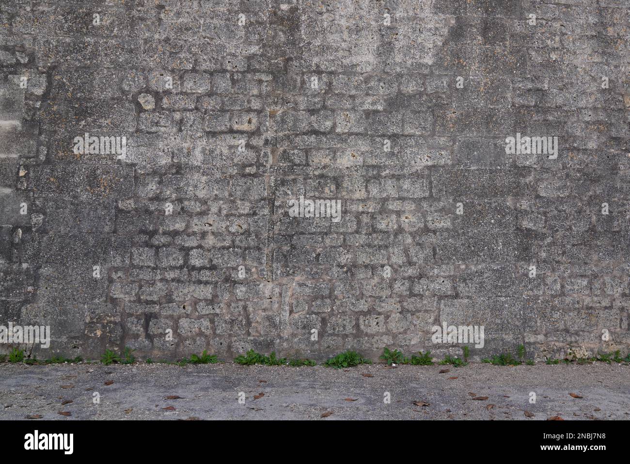 Stone facade grey street wall assembled with gray pebbles of different ...