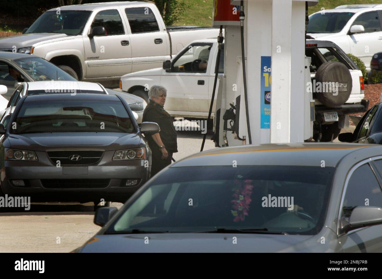 A woman pumps gas at a crowded Little Rock, Ark., Shell gas station ...