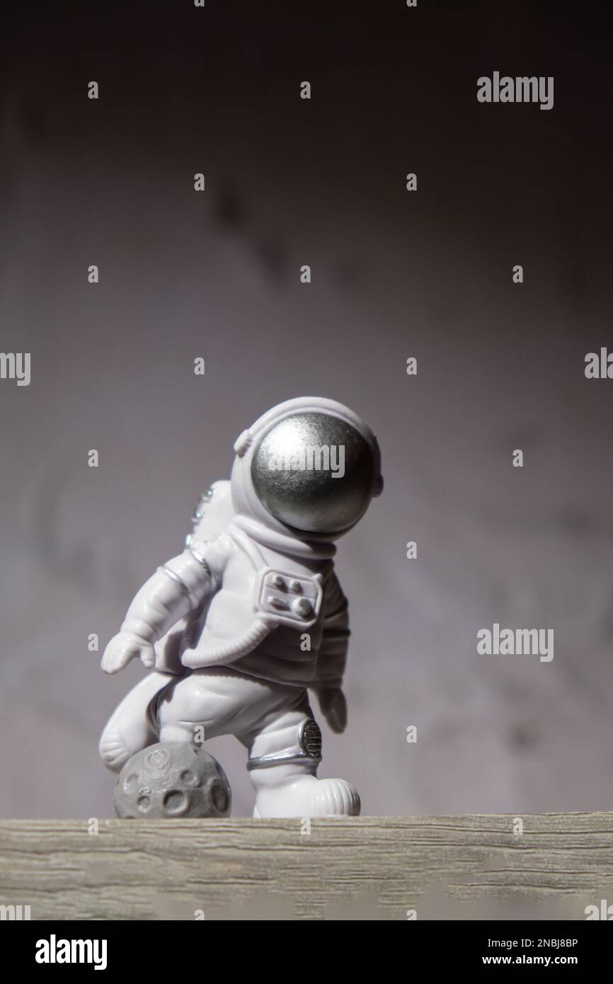 Plastic toy figure astronaut on moon concrete background Copy space ...