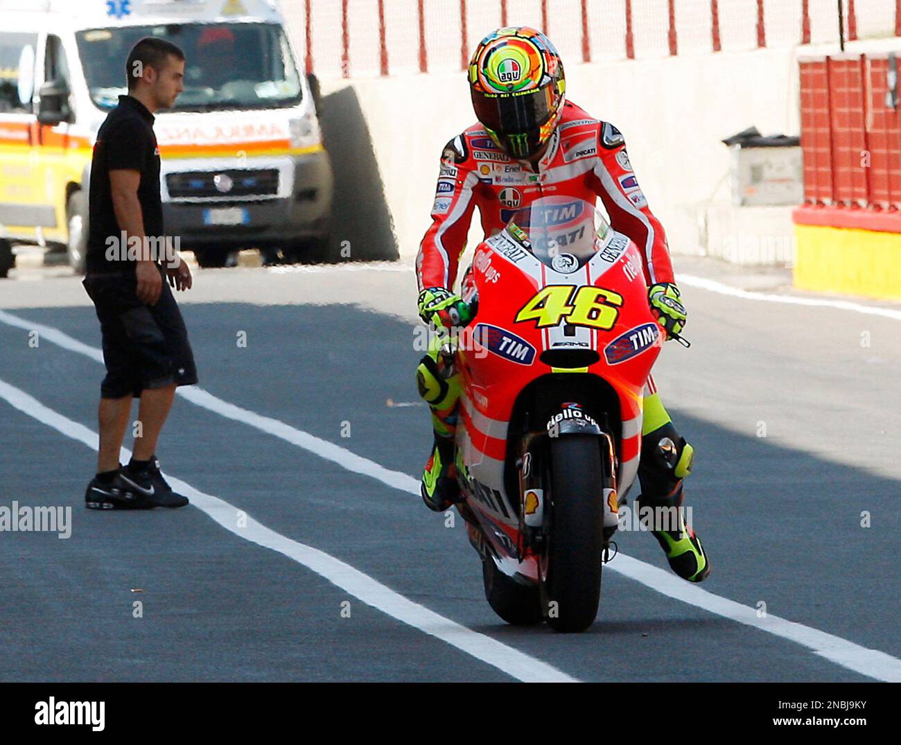 Ducati rider Valentino Rossi of Italy, right, approaches the paddock ...