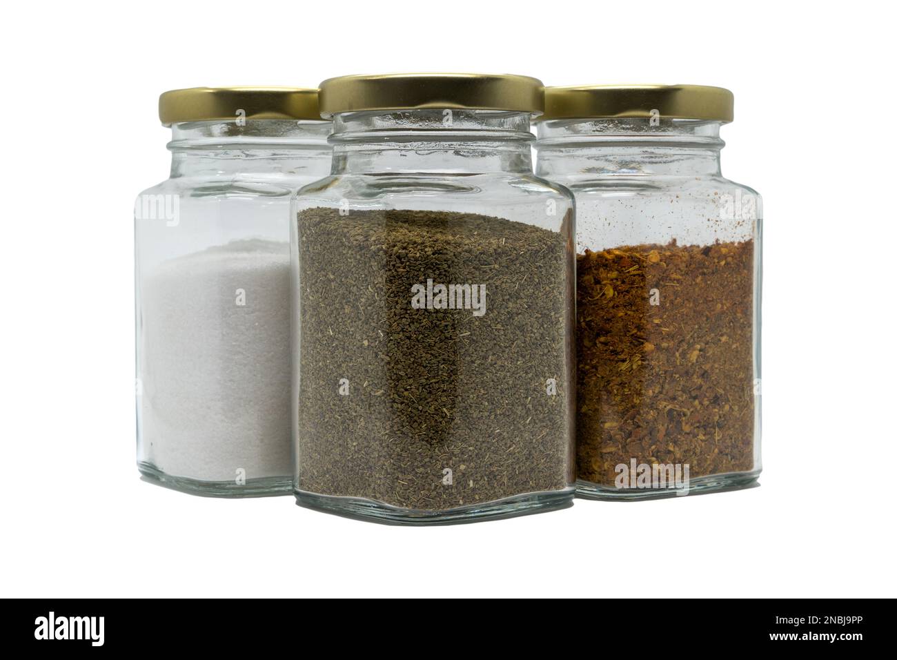 Three glass jars with spices. Celery seeds, salt and chili powder ...