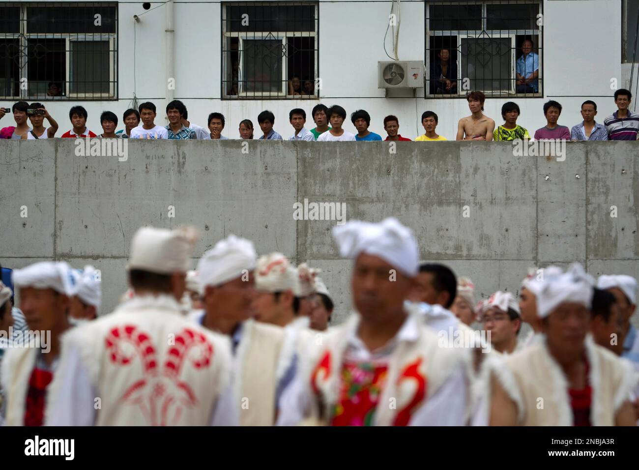 People watch drum dance performers prepare to play during a government ...