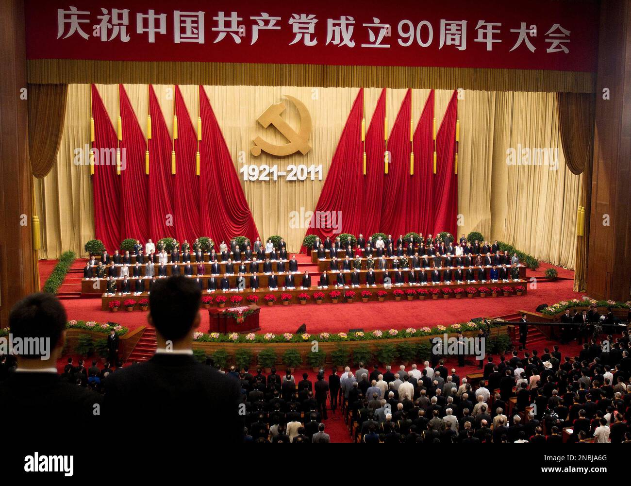 Members of the Communist Party stand and sing a patriotic song during ...