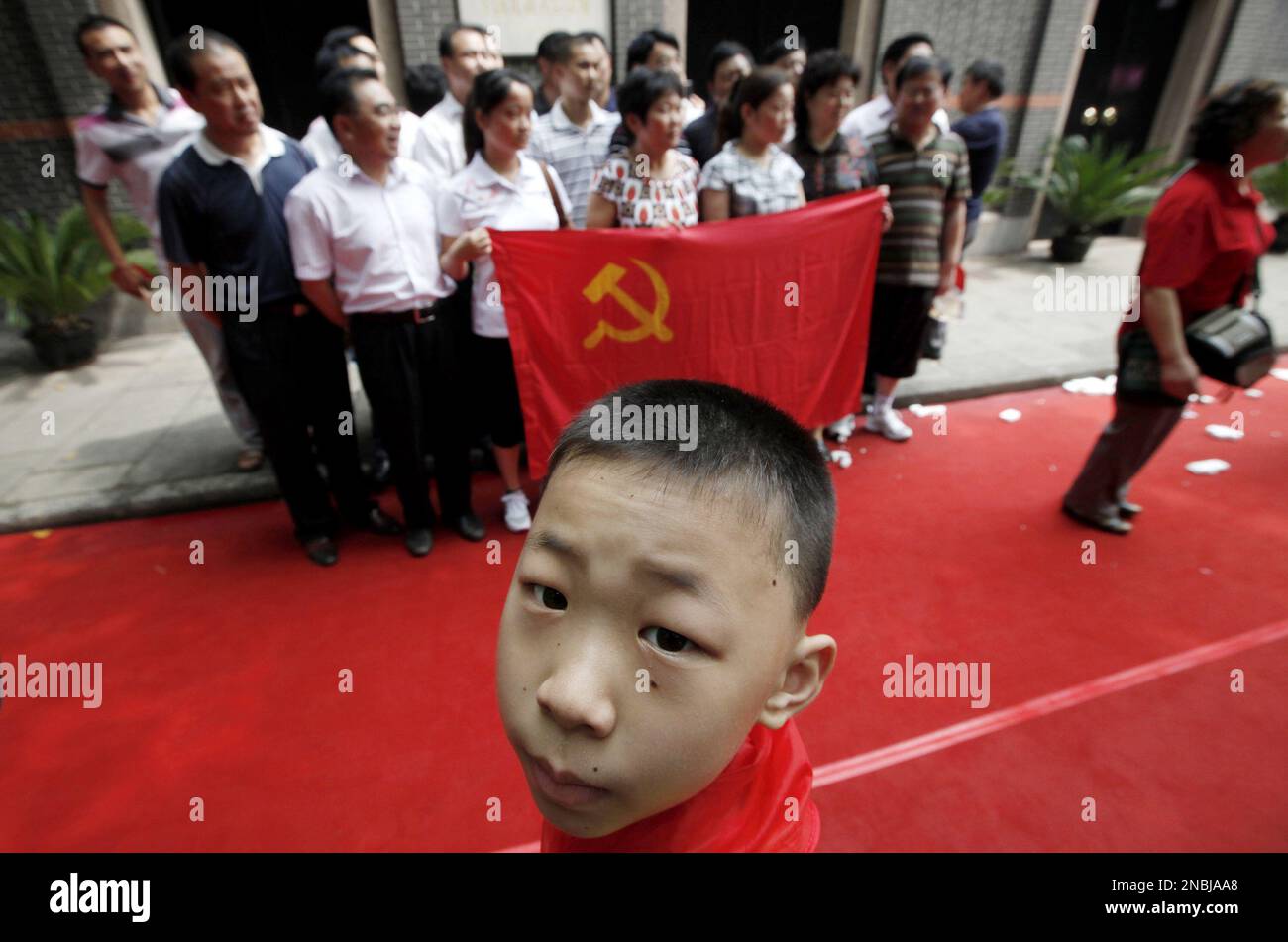 A child stands as party members pose for phopto at the Site of the ...