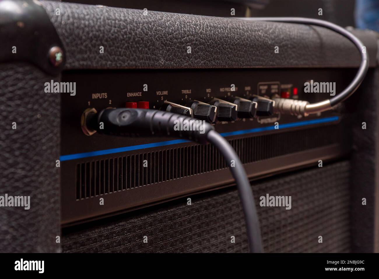 Plug jack with cable plugged into a black guitar combo amplifier Stock ...