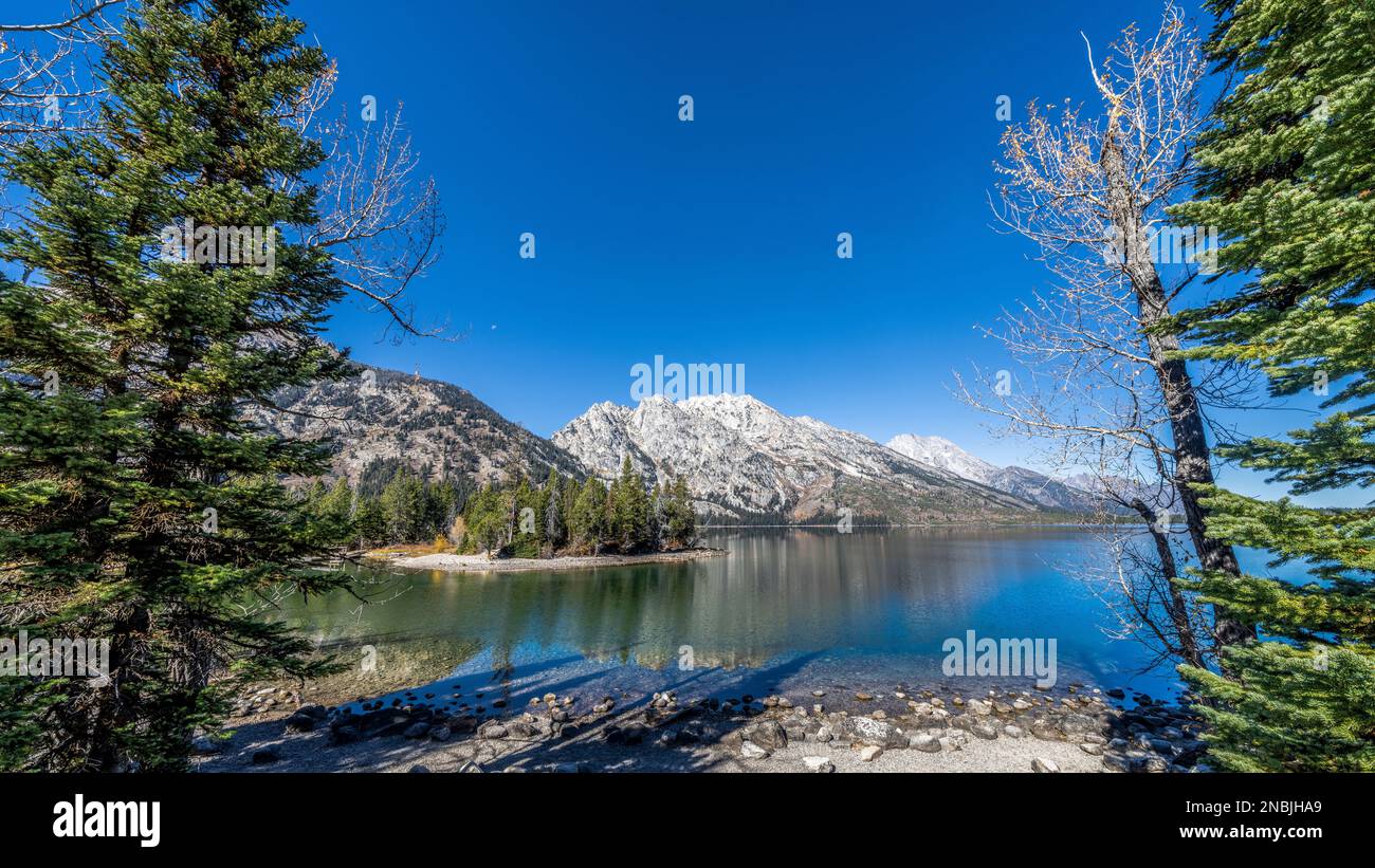 An aerial view of Jenny lake surrounded by mountains and dense trees ...