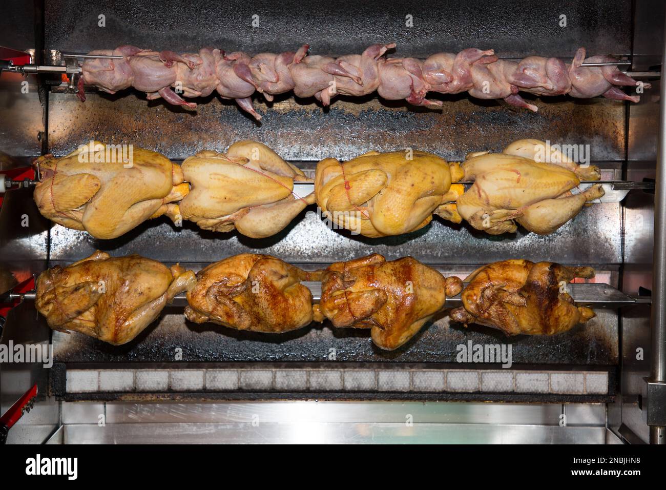 Roasted chickens in a row in a shop roaster Stock Photo - Alamy
