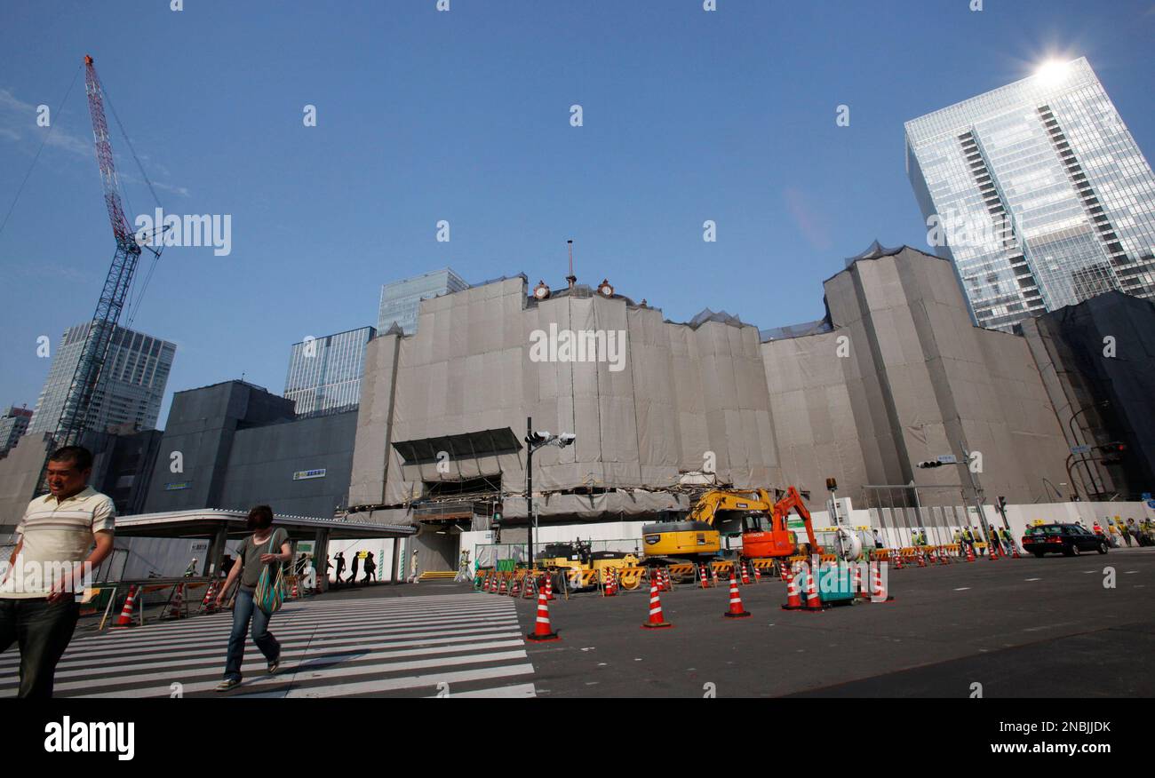 A crane and heavy machineries are used to redecorate Tokyo Station to ...
