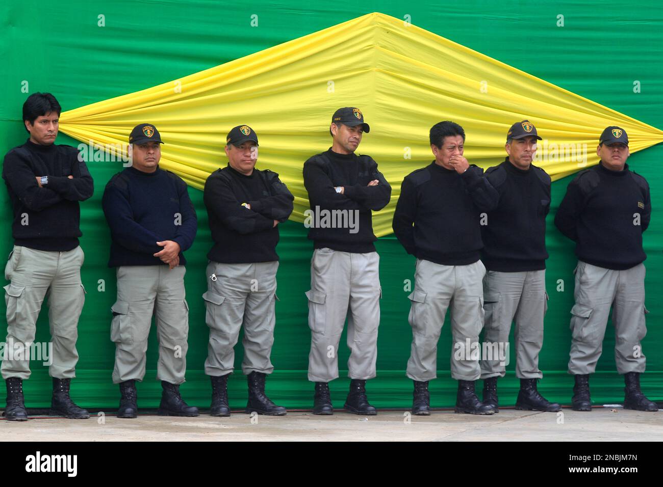 Prison guards standing in front of a Brazilian flag watch a “fulbito ...