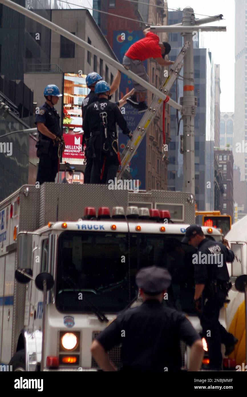 New York City police officers watch as an unidentified man who climbed ...