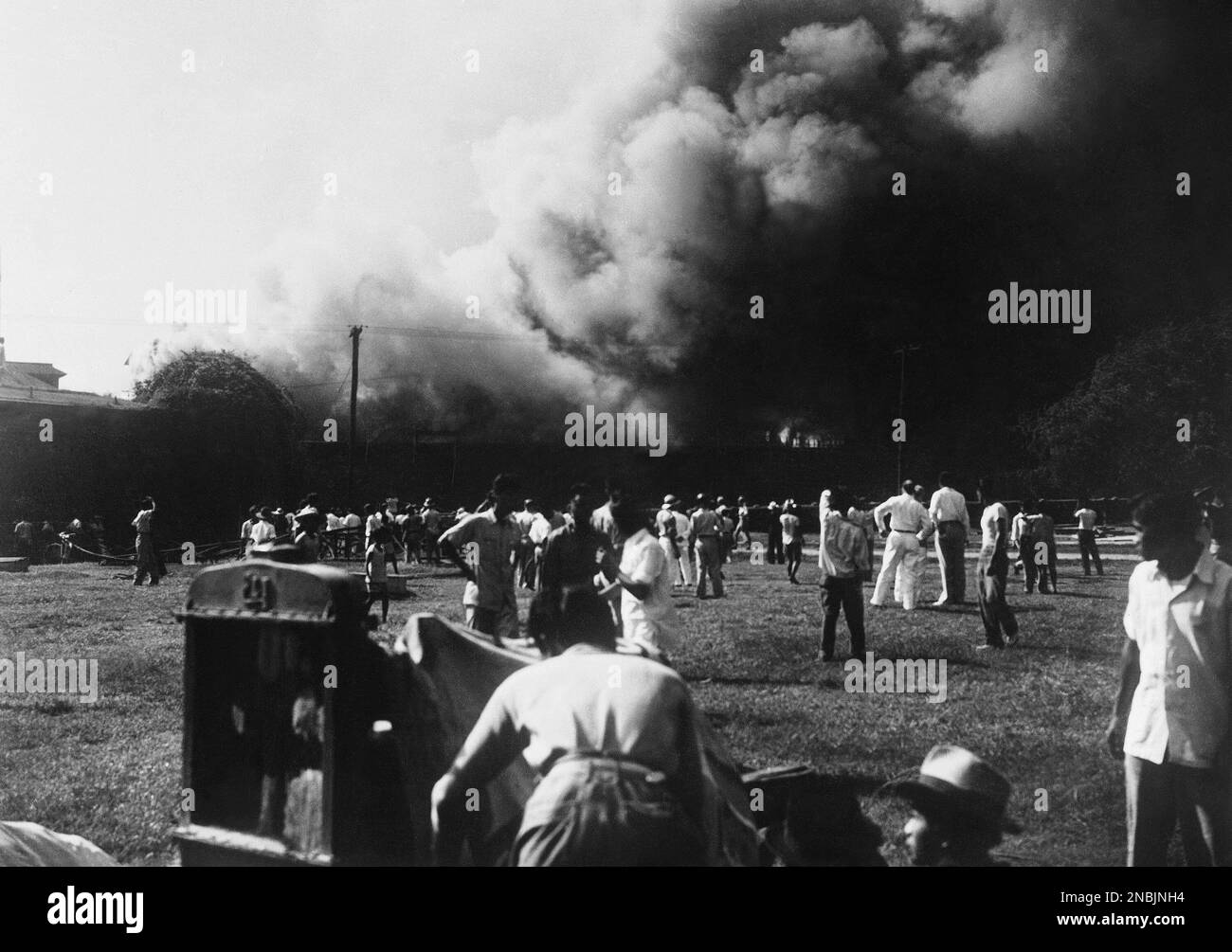 Billows of smoke from burning buildings pour over the wall which ...