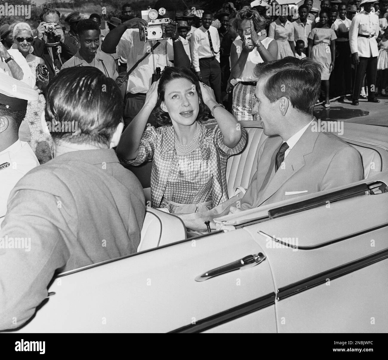 Britain’s Princess Margaret smoothes back her windblown hair under the ...