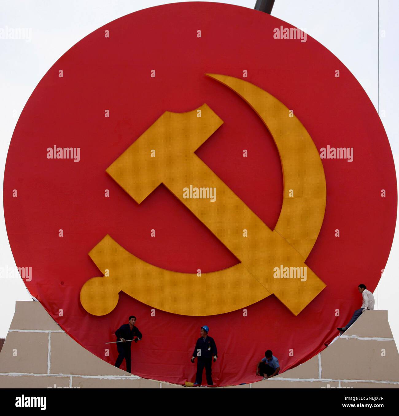 Chinese workers install a giant communist party symbol to celebrate the ...