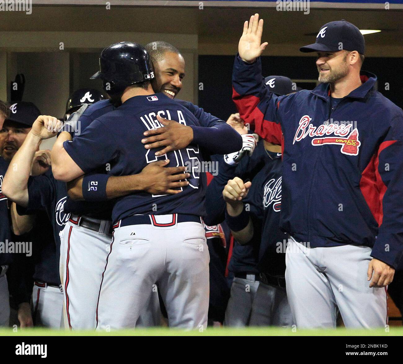 Atlanta Braves' Dan Uggla gets a hug from Jason Heyward as he returns ...