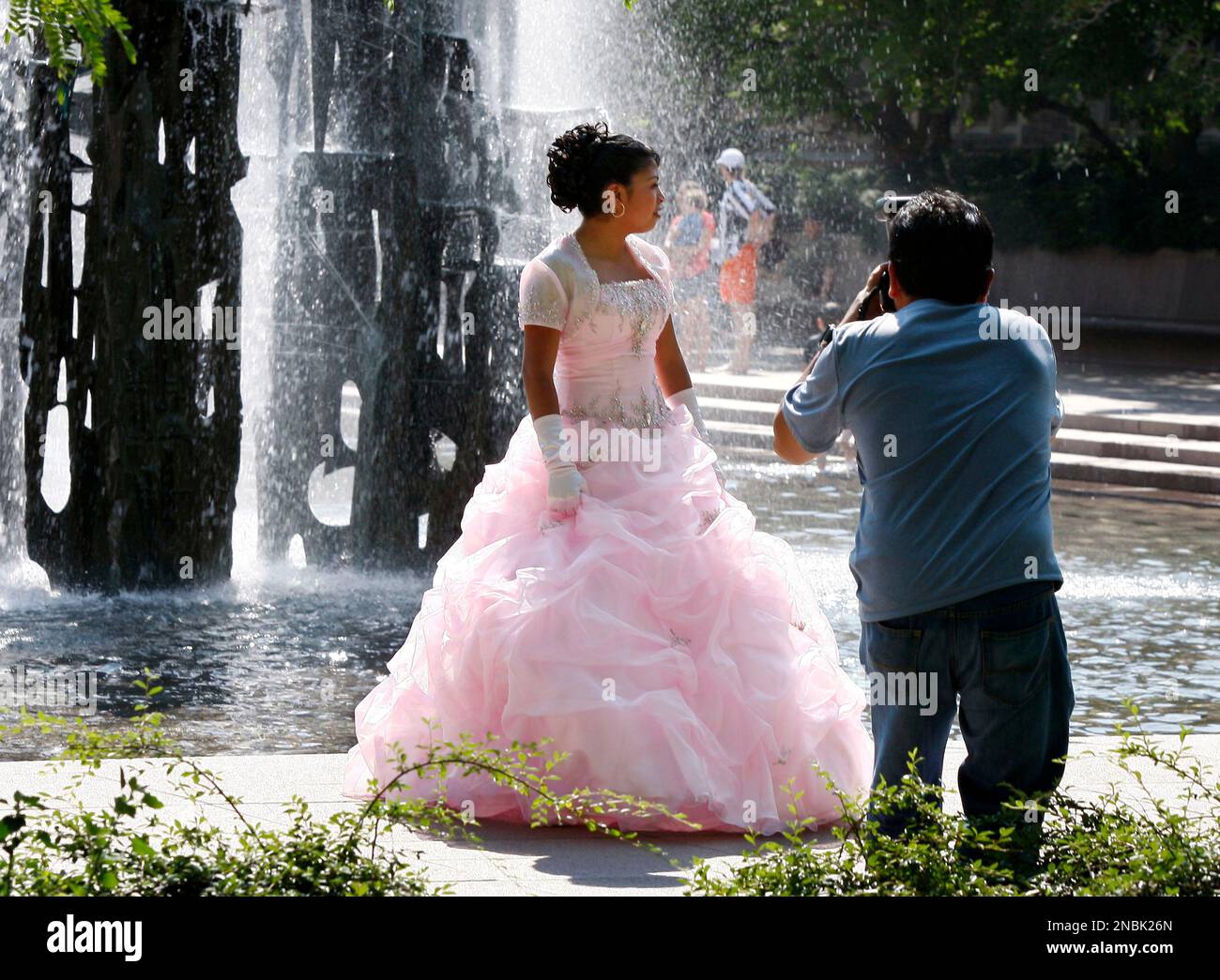 Doraliz Vasquez, of Princeton, wears a formal pink dress while having ...