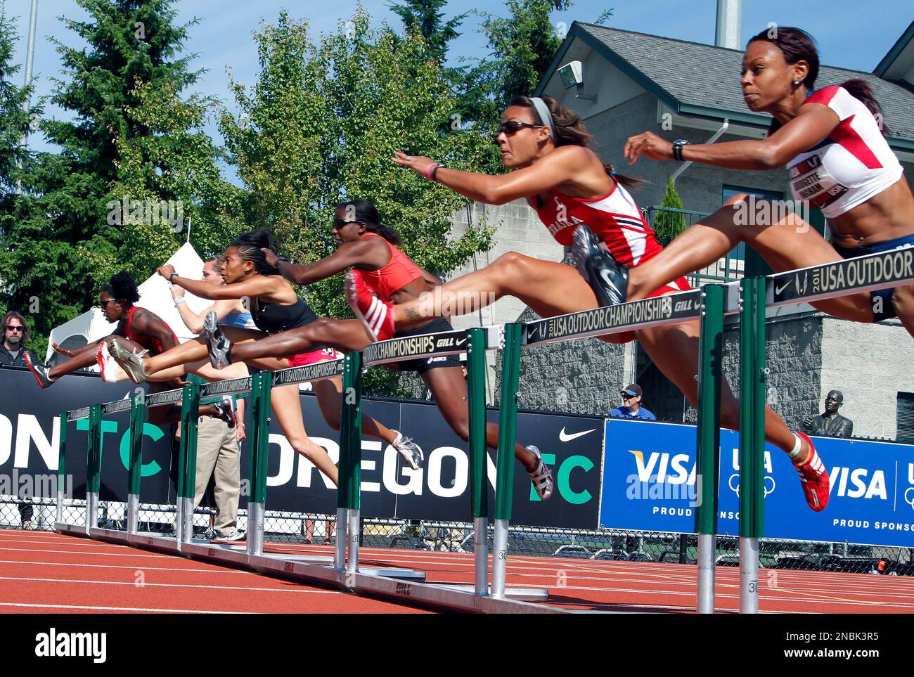 Competitors in the first heat of the heptathlon 100 meter hurdles clear ...