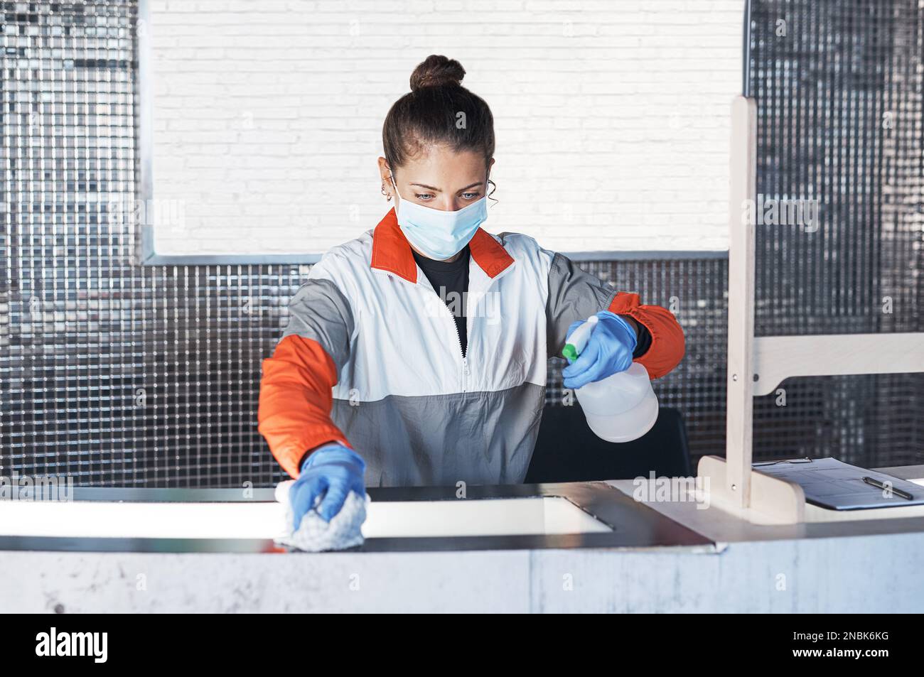 Keeping all surfaces safe from germs. a young woman cleaning the ...