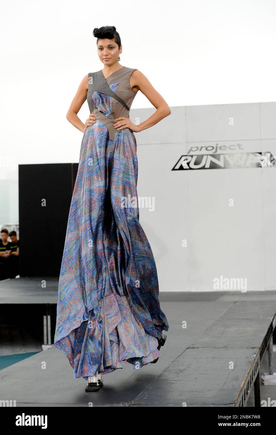 A model on stilts walks the runway during an outdoor 'Project Runway ...