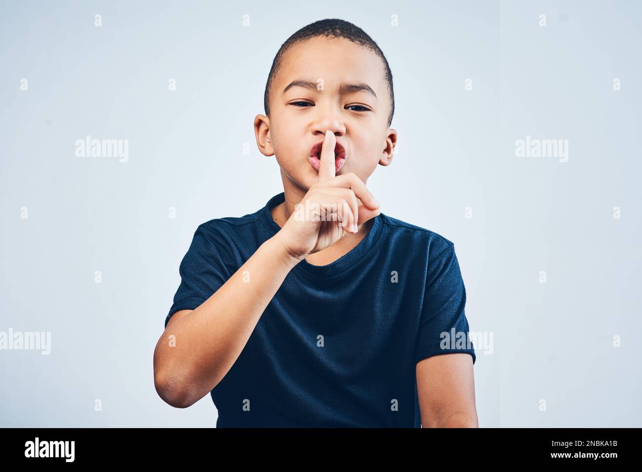Telling secrets spells trouble. Studio shot of a cute little boy posing ...