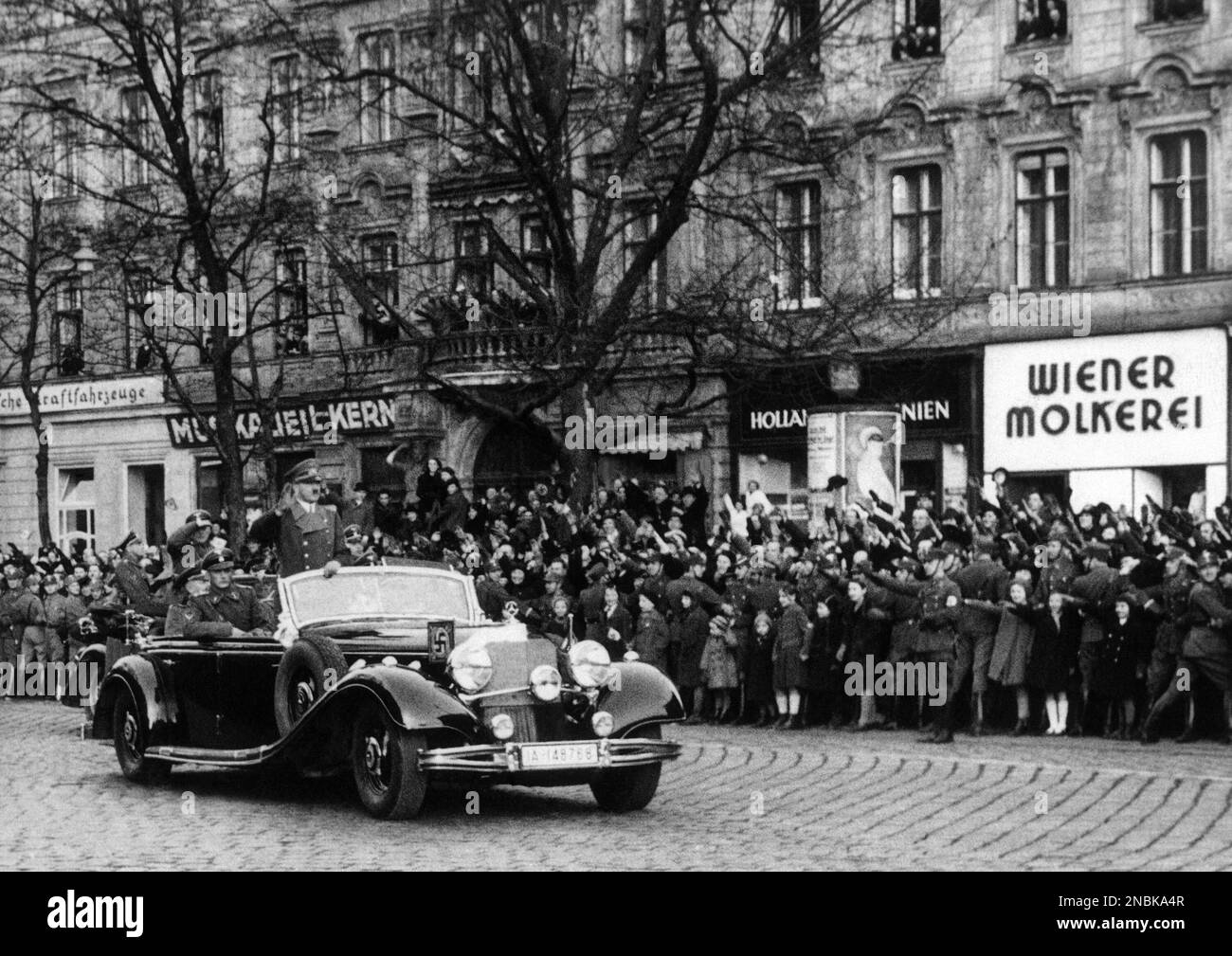 German Chancellor Adolf Hitler standing in his car saluting the ...