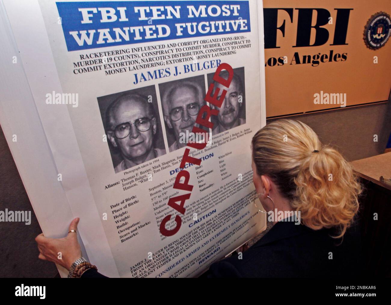 FBI Special Agent Mary Prang sets up a 'wanted' poster overstamped ...