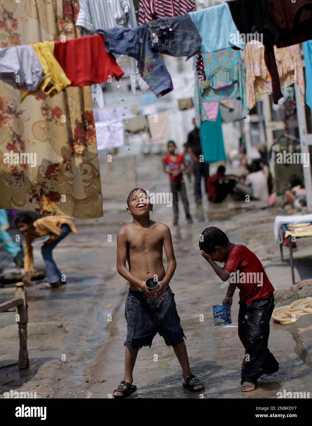 Pakistani children play with water to cool off as the temperature rises ...