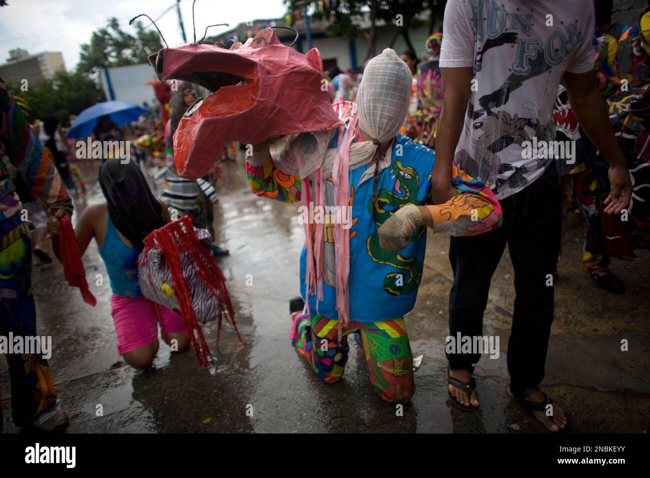 A person dressed as a dancing devil walks on his knees to give thanks ...