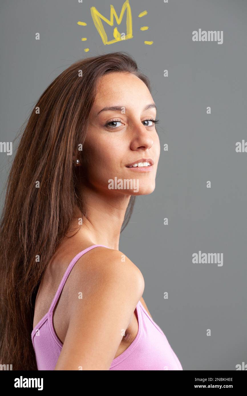glance over her shoulder in a portrait of a slim young woman in a pink ...