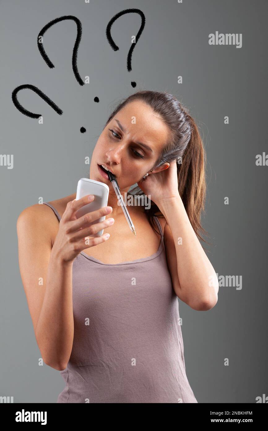 young woman with the appearance of a college student, has a pen between ...