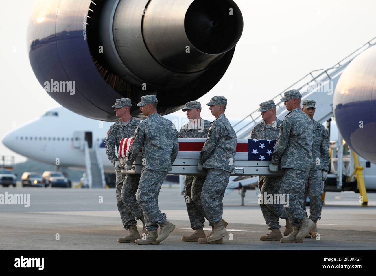 An Army carry team carries the transfer cases containing the remains of ...