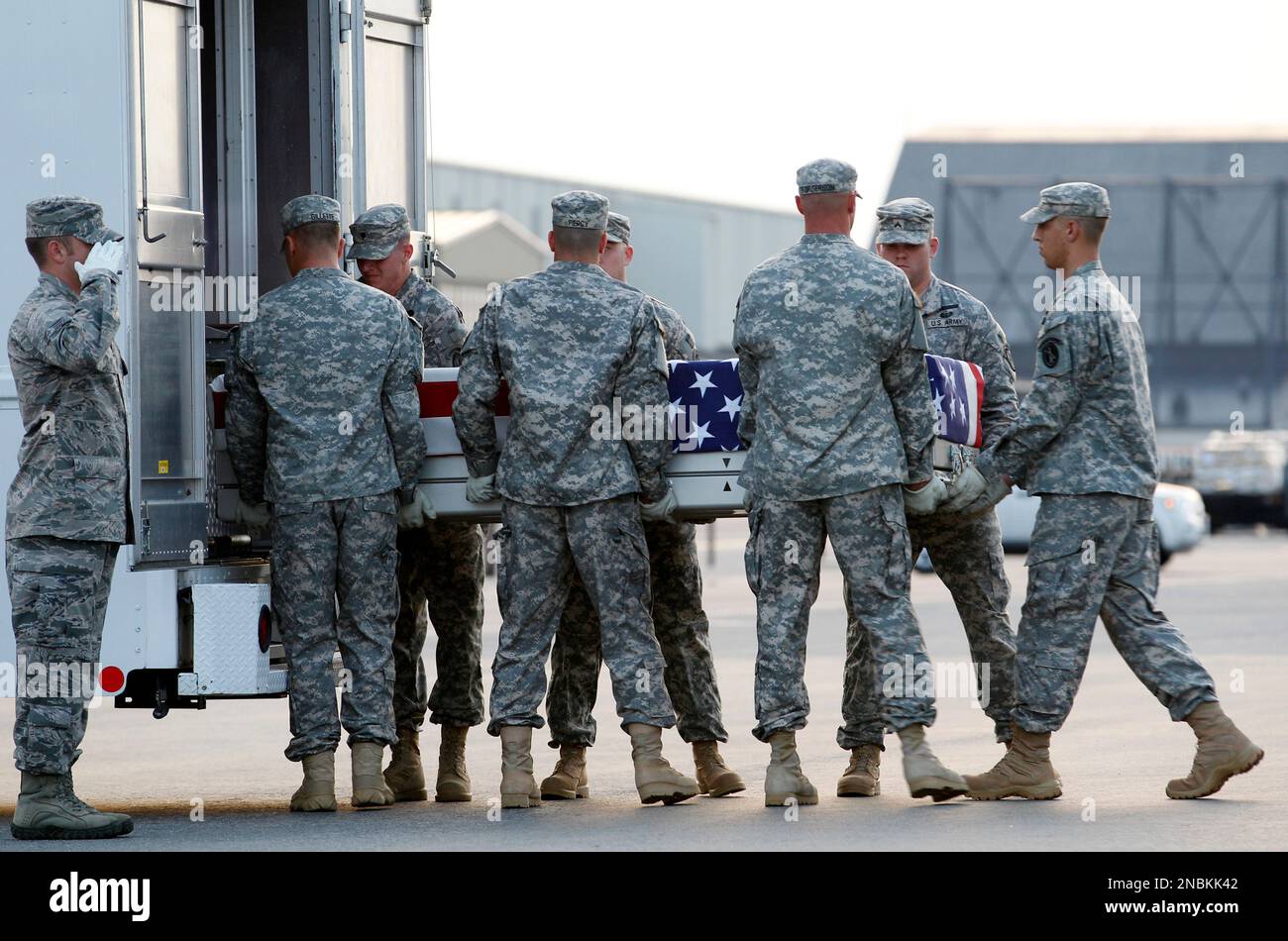An Airmen carry team carries the transfer case containing the remains ...