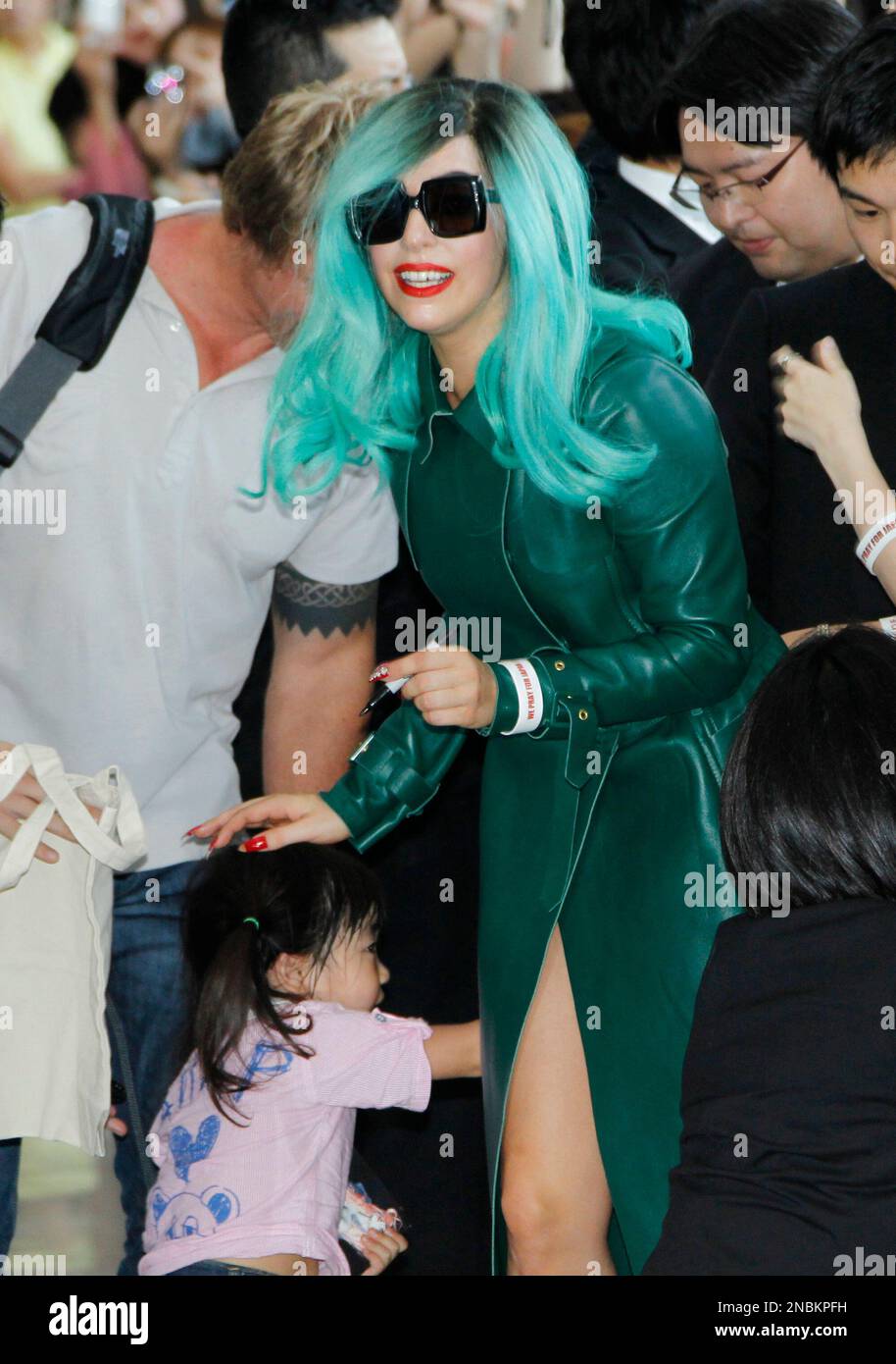 Singer Lady Gaga prepares to sign her autograph upon arrival at Narita ...