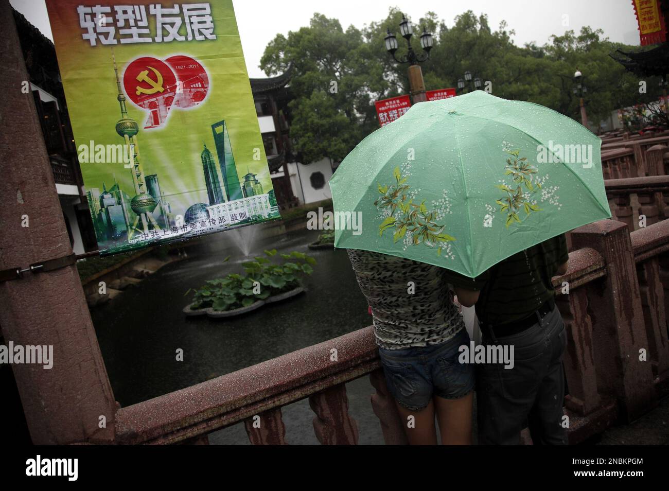 A couple look at a traditional garden next to the advertisement to ...