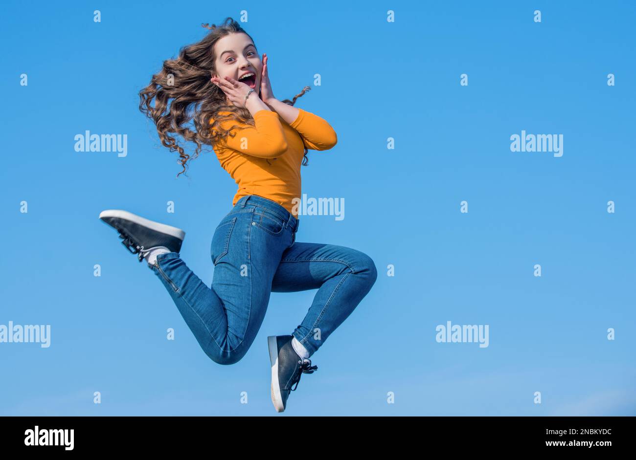 surprised teen girl jump high on sky background Stock Photo - Alamy