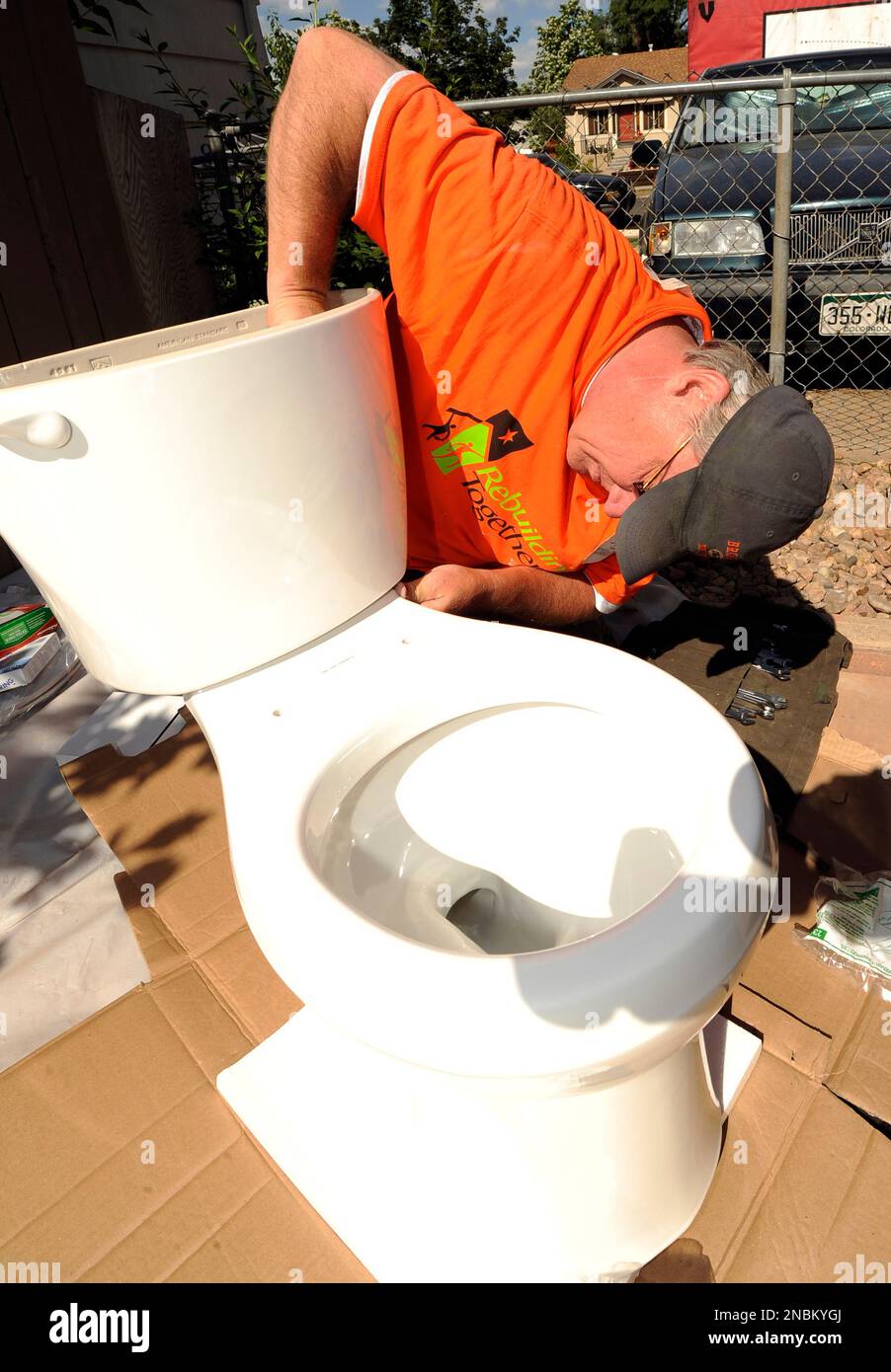 A volunteer assembles a toilet at Rebuilding Together's Building a ...