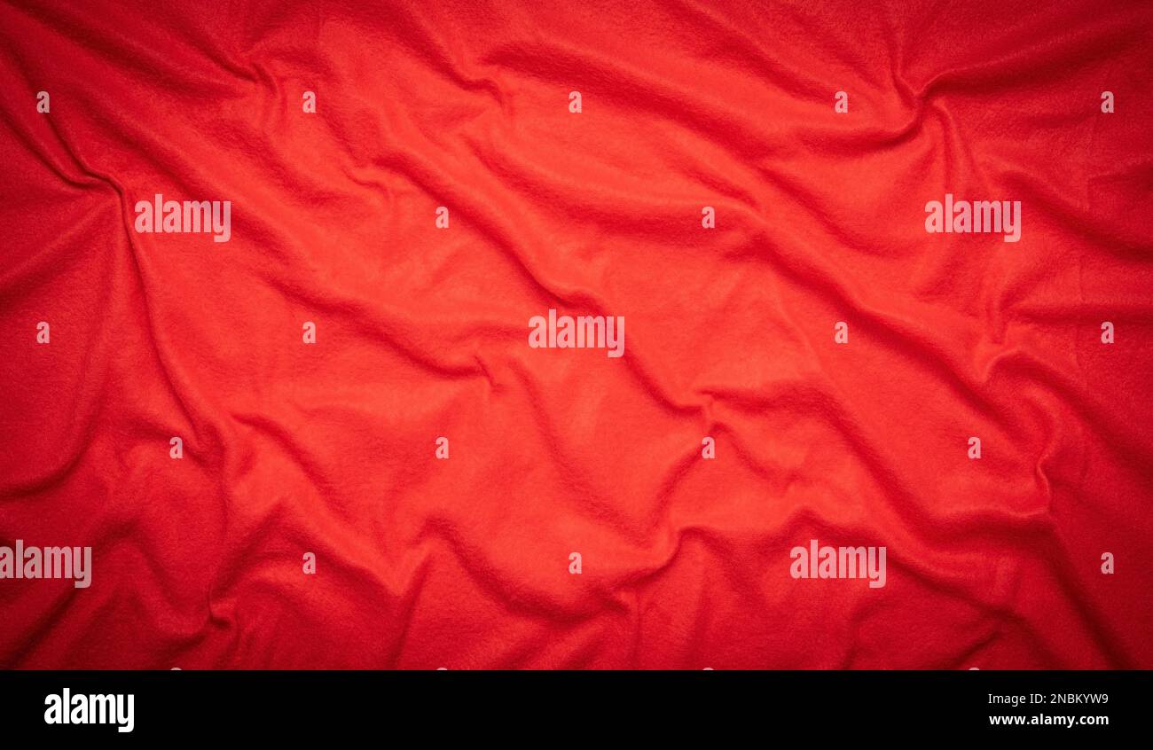 Abstract background of bright crumpled soft red fabric with vignette ...