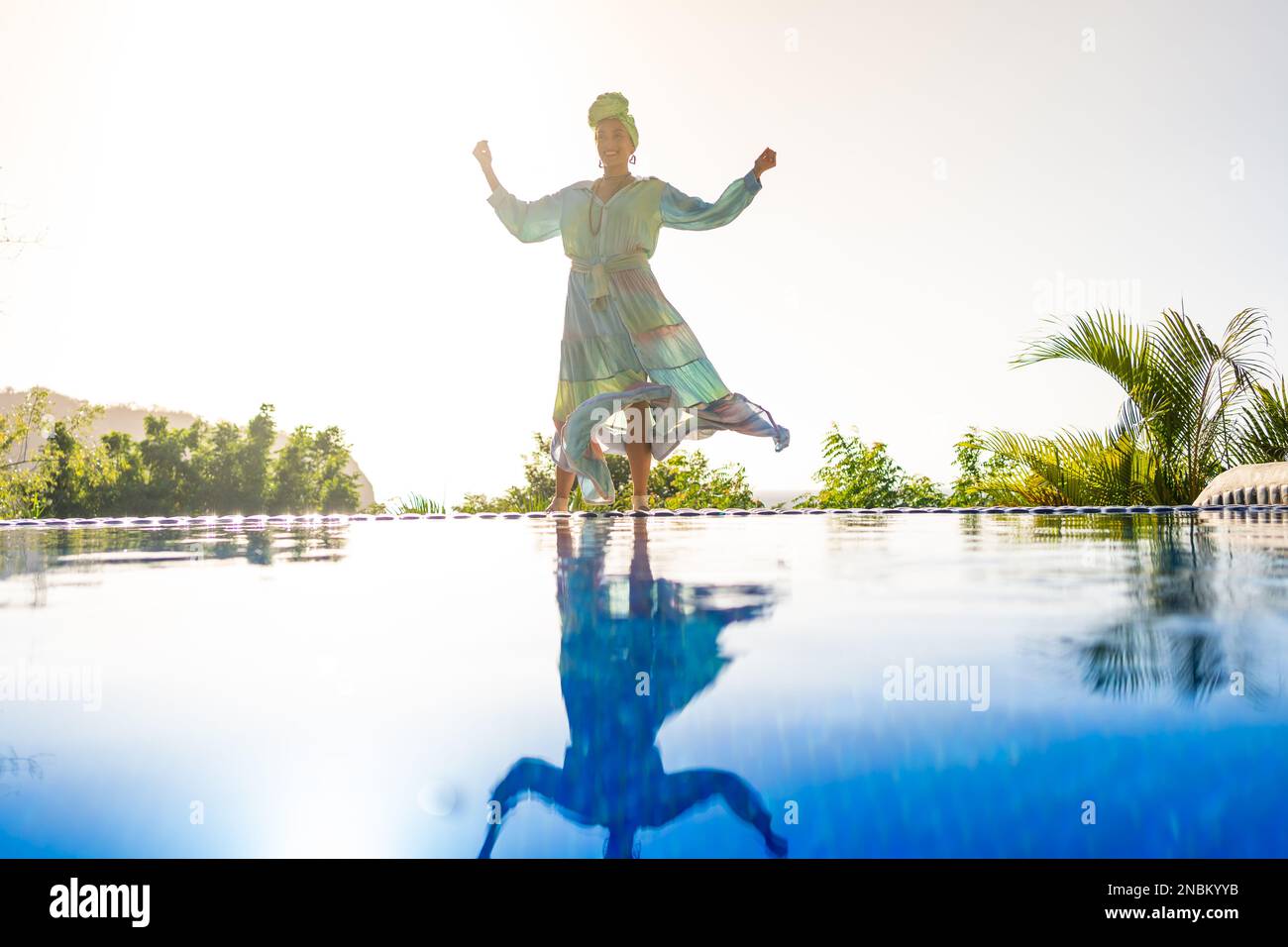 Exotic woman dancing with long dress next to a swimming pool Stock ...